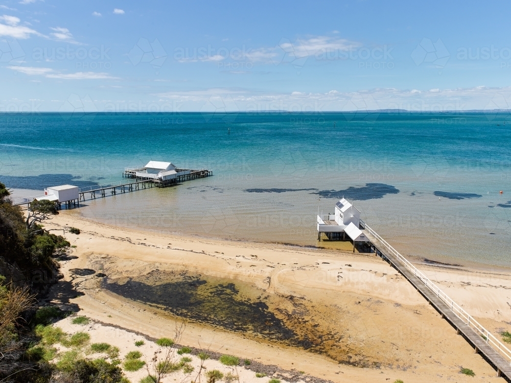 Image of private jetties and boatsheds from coastal walkway - Austockphoto