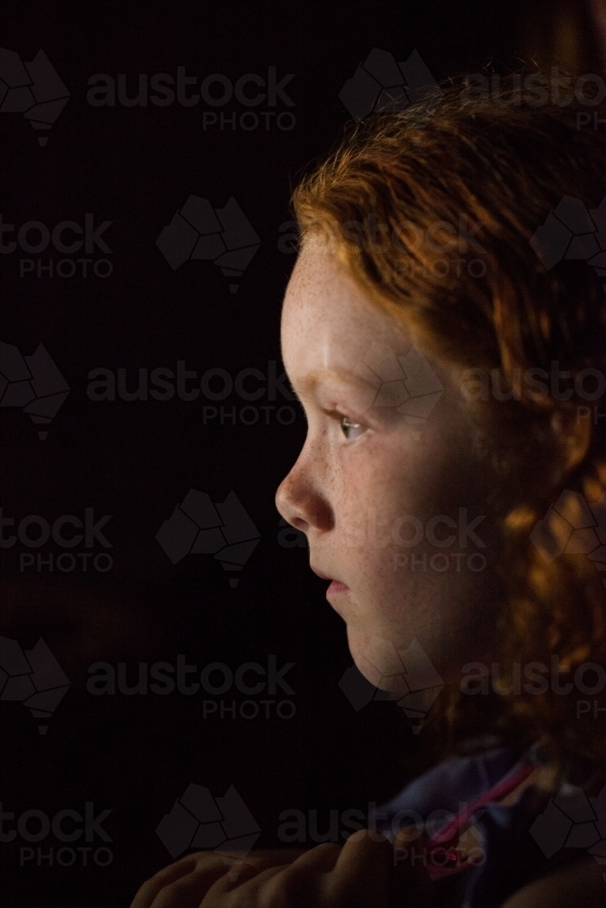 Image of Profile of a young girl in low light - Austockphoto