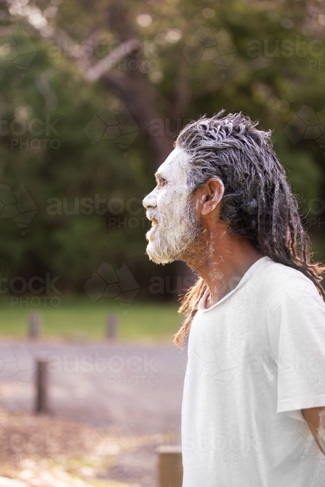 Image of Profile portrait of aboriginal man against a dark bush ...