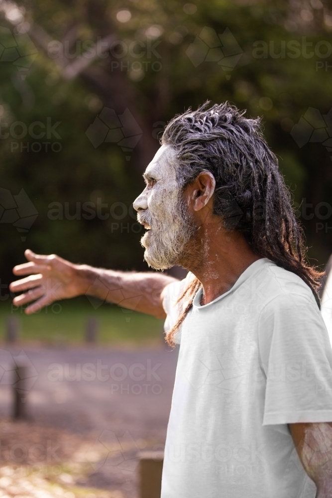 Image of Profile portrait of aboriginal man against a dark bush ...