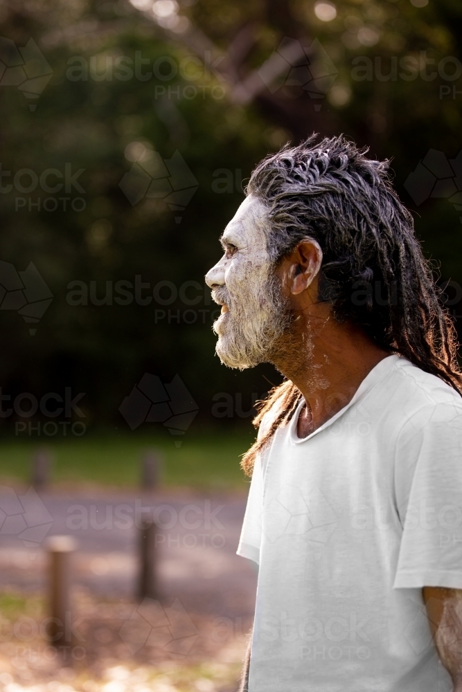 Image of Profile portrait of aboriginal man against a dark bush ...
