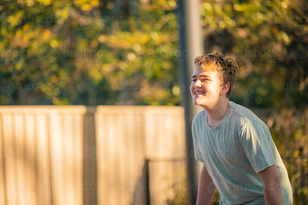 Image of Profile portrait of teenage boy with cheeky grin - Austockphoto