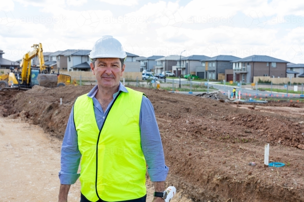 Image of Property developer standing at front of housing estate ...