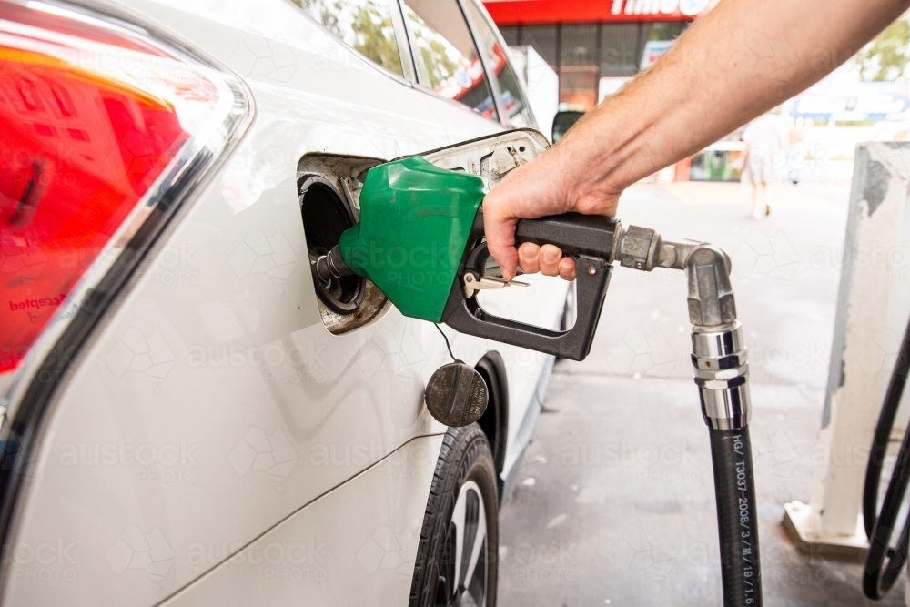 Image of pumping petrol at a servo in the day time - Austockphoto