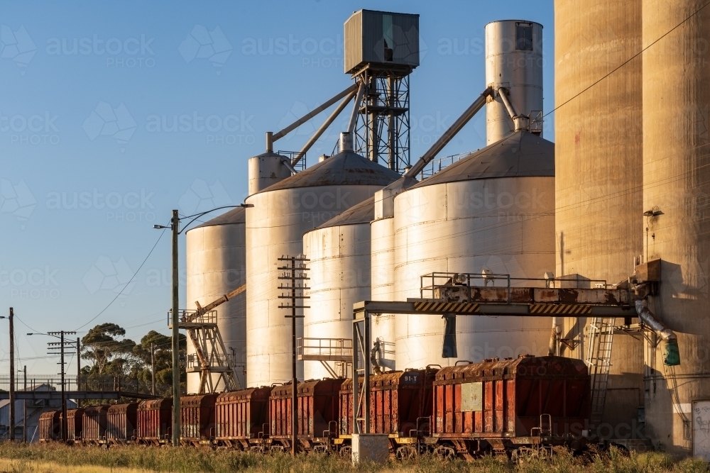 Image of Railway carriages lined up alongside tall grain silos in a ...