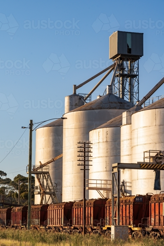 Image of Railway carriages lined up alongside tall grain silos in a ...
