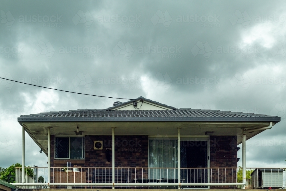 Image of Rain and storm clouds and suburban house - Austockphoto