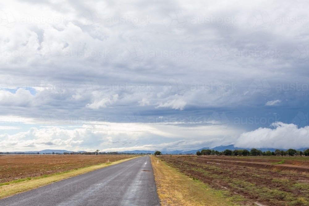 Image of Rain storm retreating into distance over country road and ...