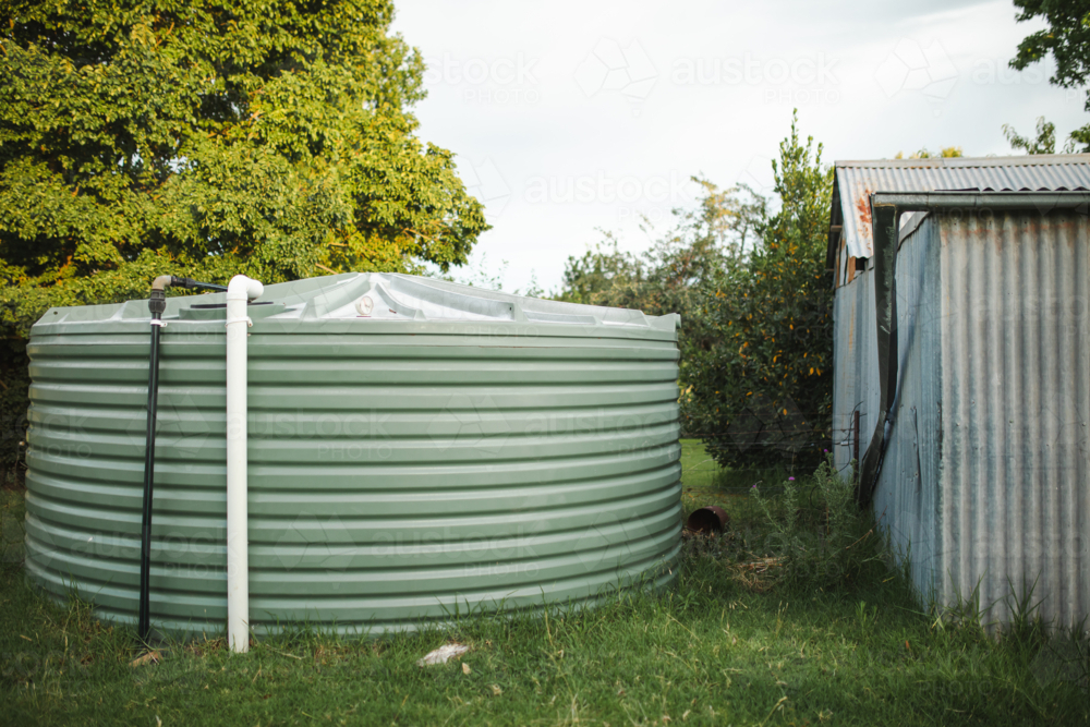 Image of Rain water tank beside shed on rural farm property - Austockphoto