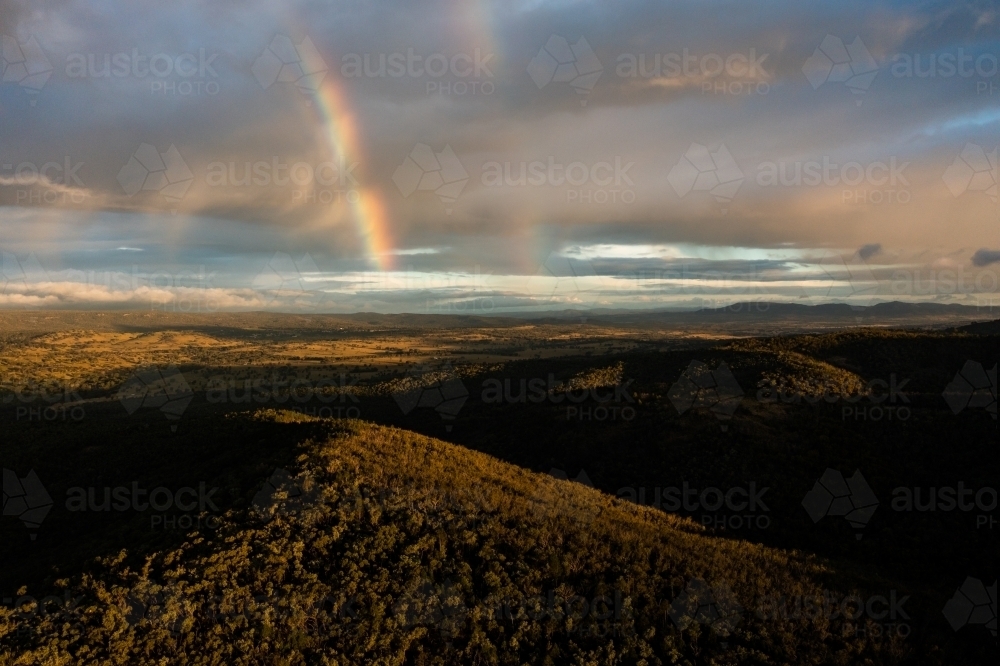 Image of Rainbow over granite belt landscape - Austockphoto