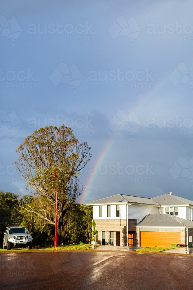 Image of Rainbow over home at the end of a cul-de-sac with storm clouds ...