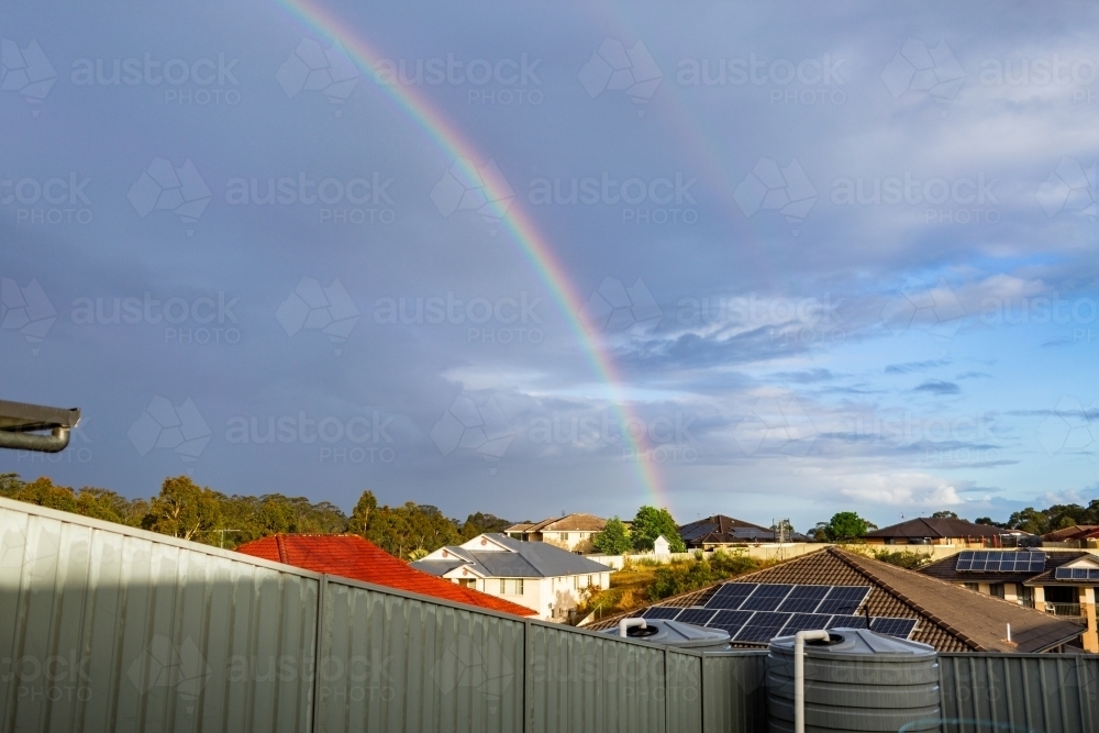 Image of Rainbow over suburban rooftops in residential area with ...