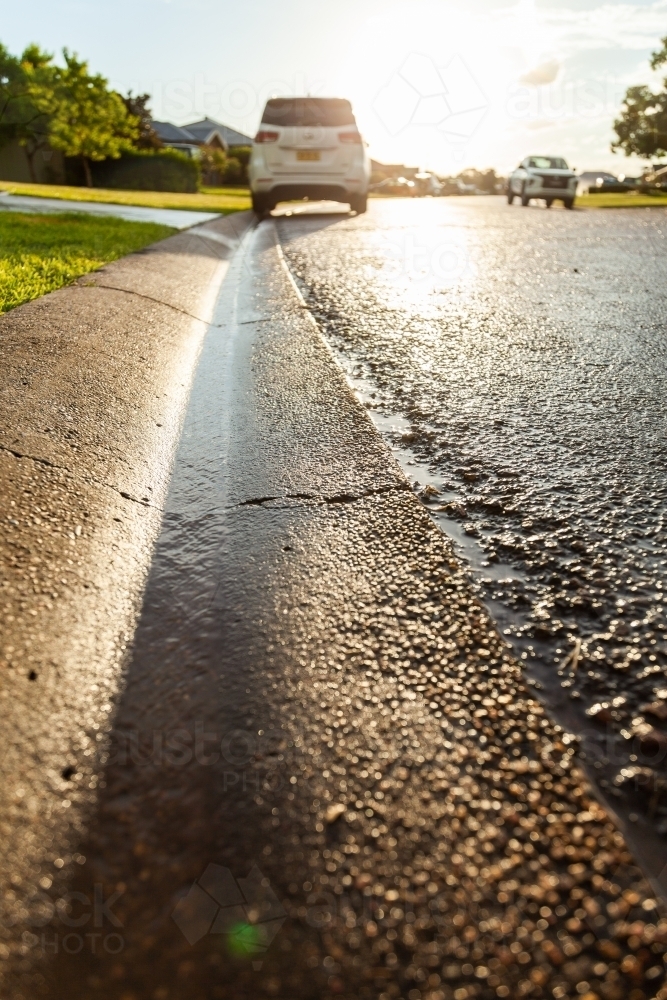 Image of Rainwater running down gutter to stormwater drain in street ...