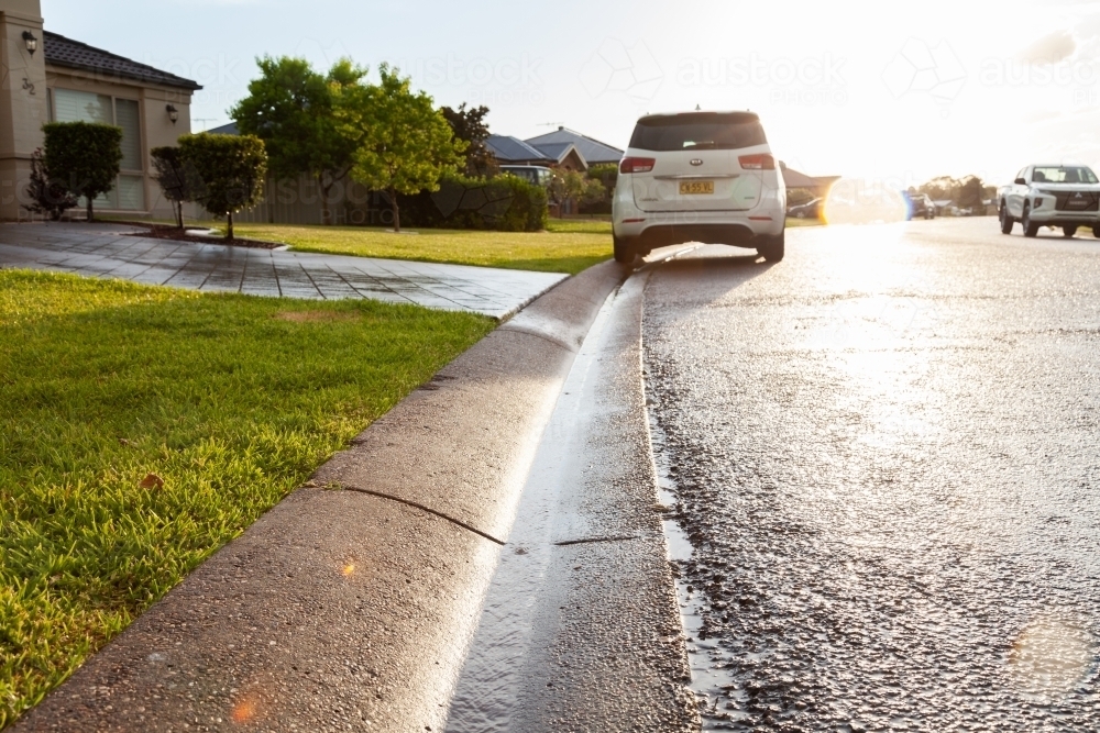 Image of Rainwater running down gutter to stormwater drain in street ...