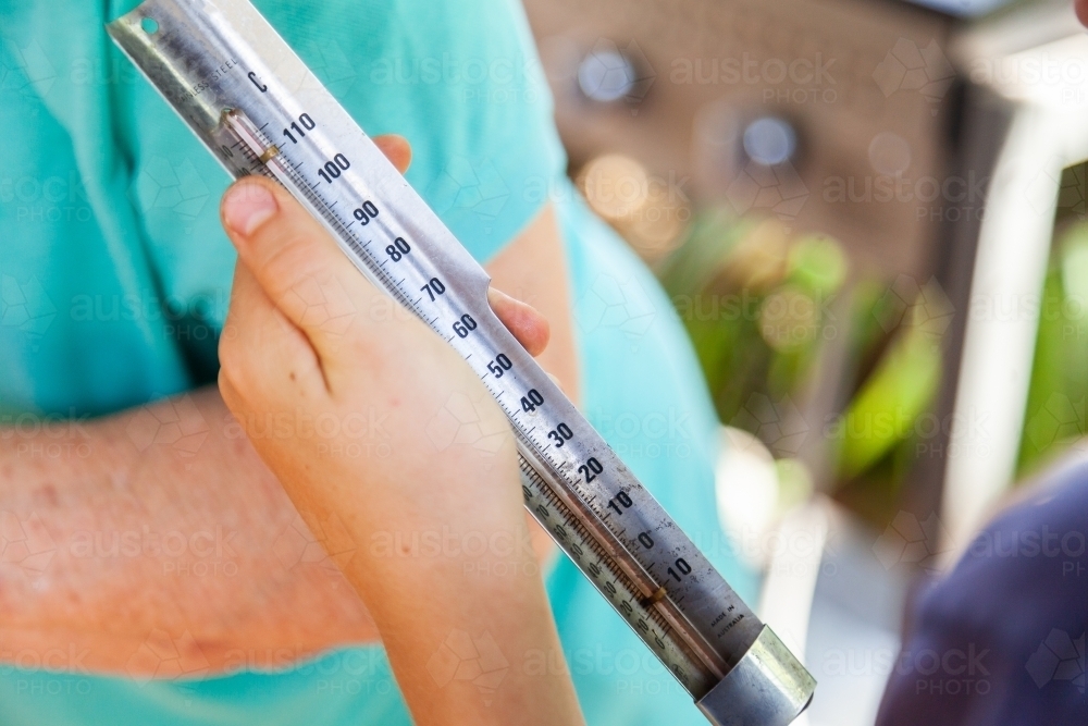 Image of Reading temperature on thermometer - Austockphoto