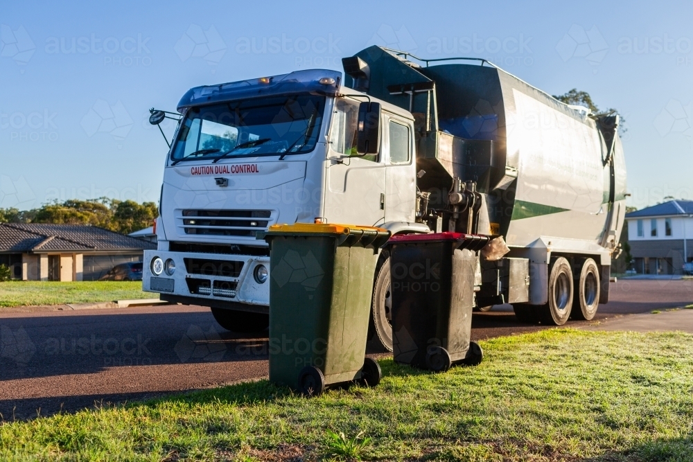 Image of Recycling truck picking up bin from suburban roadside ...