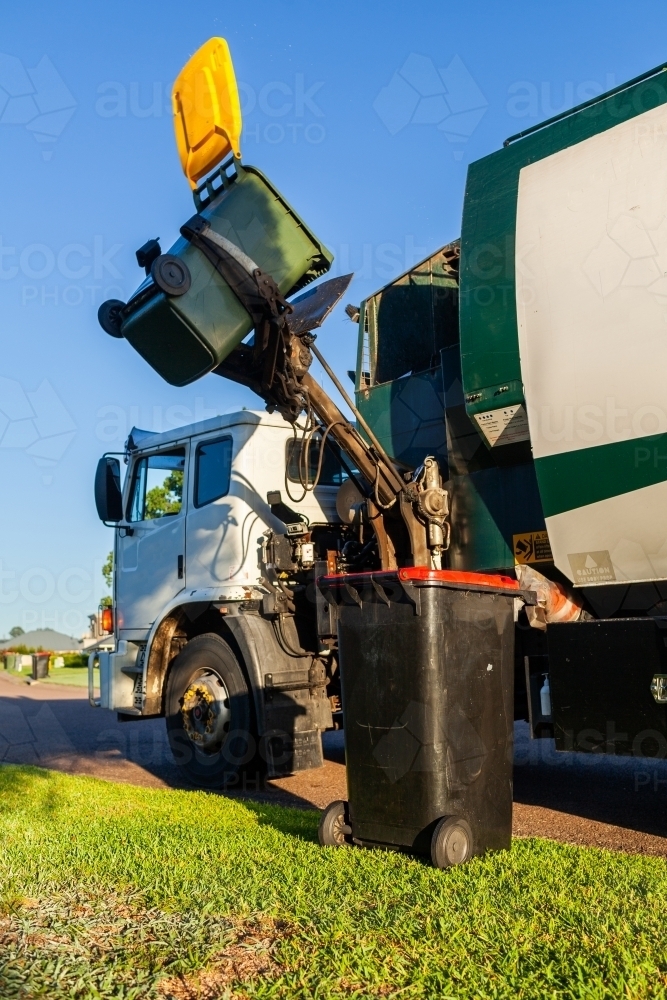 Image of Recycling truck picking up bin from suburban roadside ...