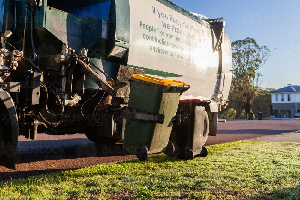 Image of Recycling truck picking up bin from suburban roadside in ...