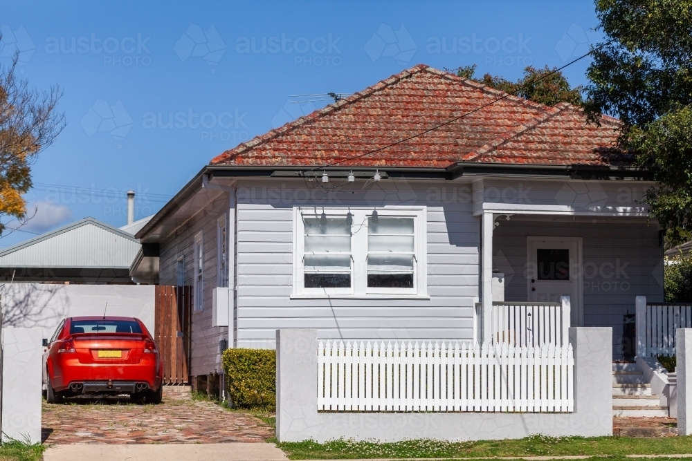 Image of red car parked in cobbled driveway of weatherboard home in ...