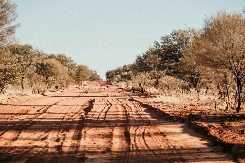 Image of Red dirt track with tyre marks in the dust. - Austockphoto