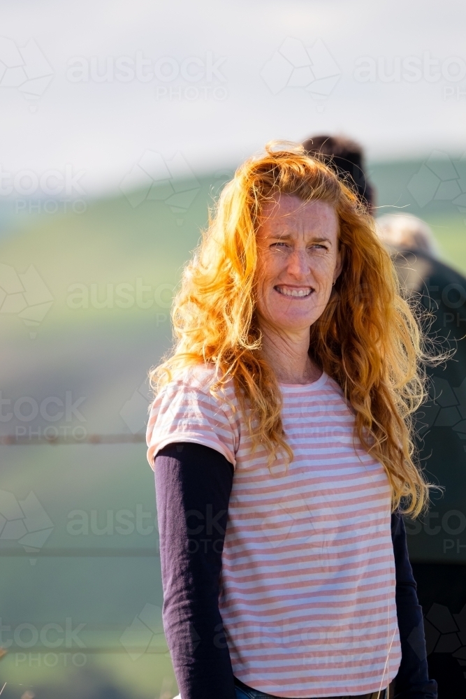 Image of Red headed lady shining in the sunlight. - Austockphoto