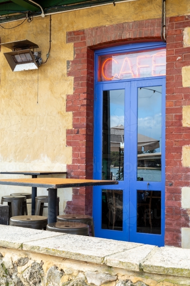 Image of Red neon cafe sign above blue door and alfresco section ...