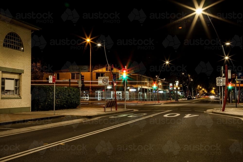 Image of Red orange and green traffic lights in a small town at night ...