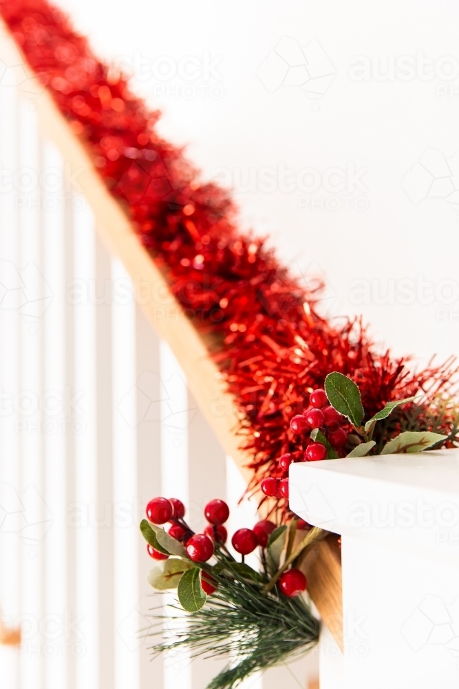 Image of red tinsel up an internal stairway banister - Austockphoto