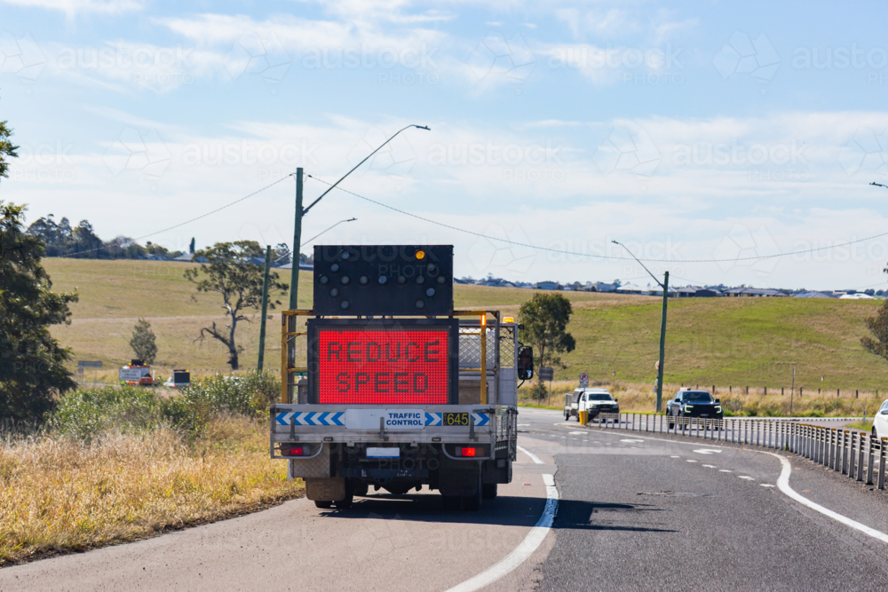 Image of Reduce speed sign in traffic control vehicle before roadworks ...