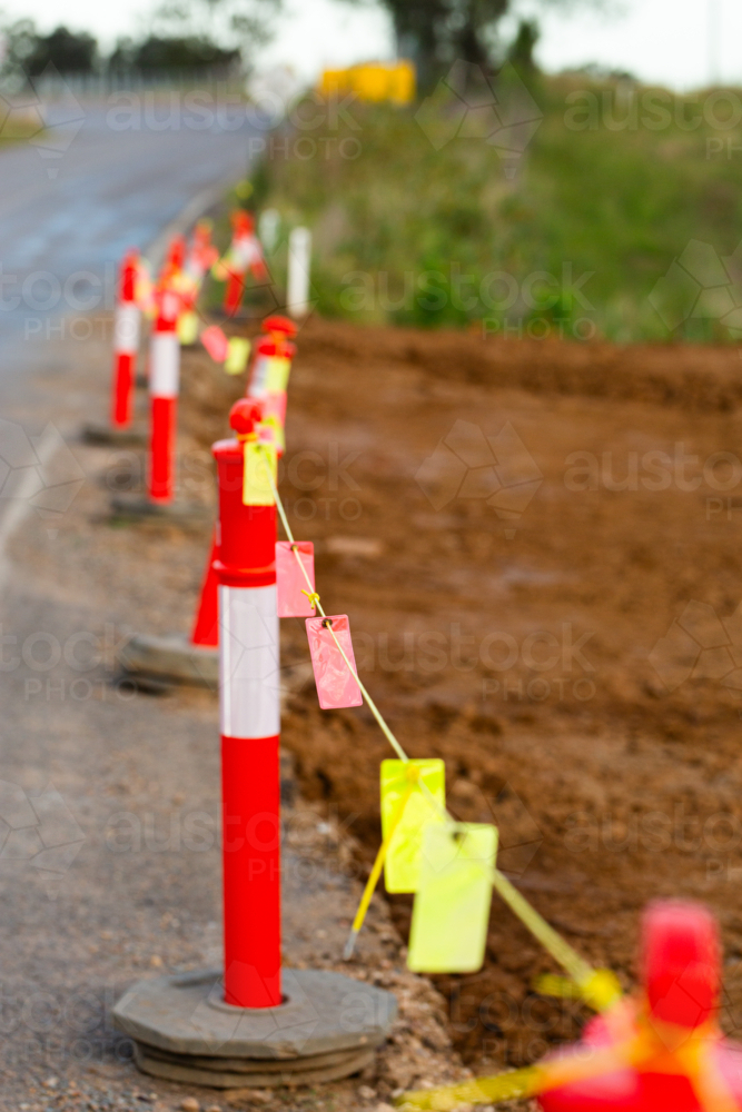 Image of Reflective tags on worksite fence beside road - Austockphoto