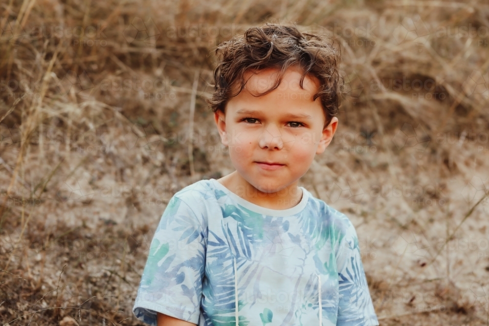 Image of Relaxed Aboriginal boy in the Australian bush - Austockphoto