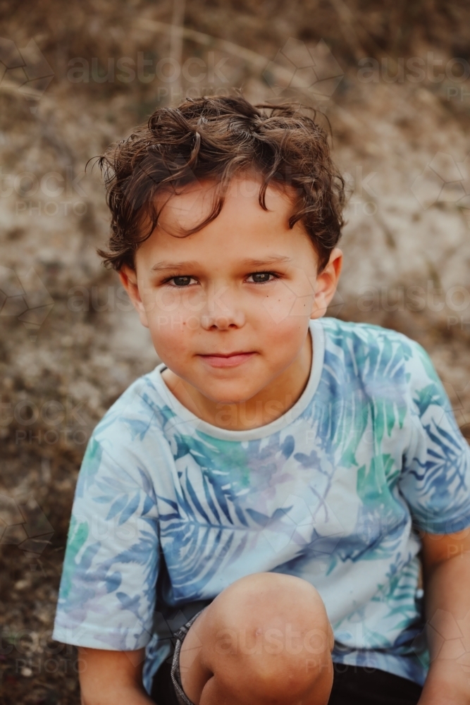 Image of Relaxed Aboriginal boy sitting in the Australian bush ...