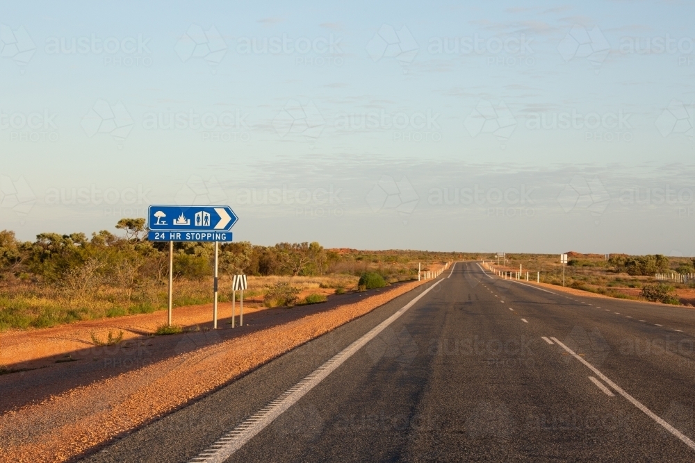 Image of Remote highway with sign for 24 hour stopping bay - Austockphoto
