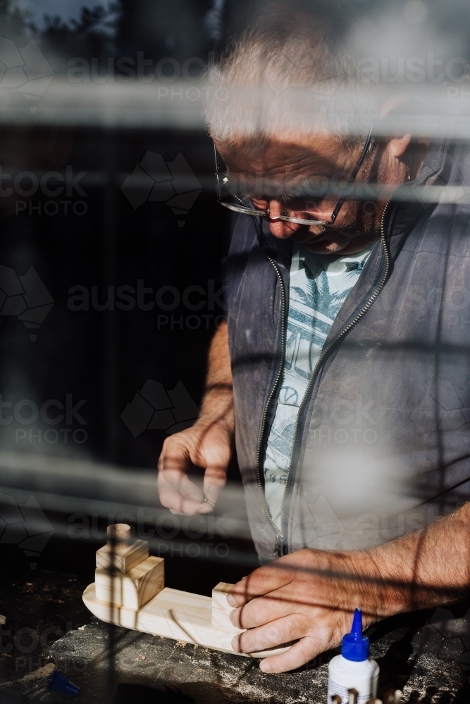 Image of Retired man doing woodwork in the shed - Austockphoto