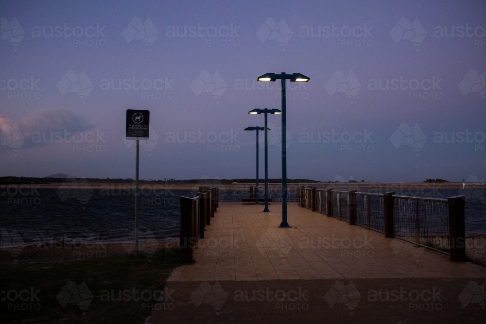Image of river jetty with lights on in dark after dusk - Austockphoto