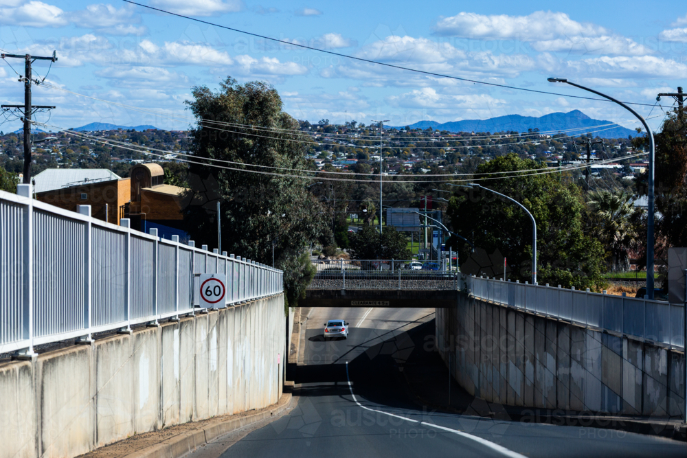 Image of road going under railway track in city - Austockphoto