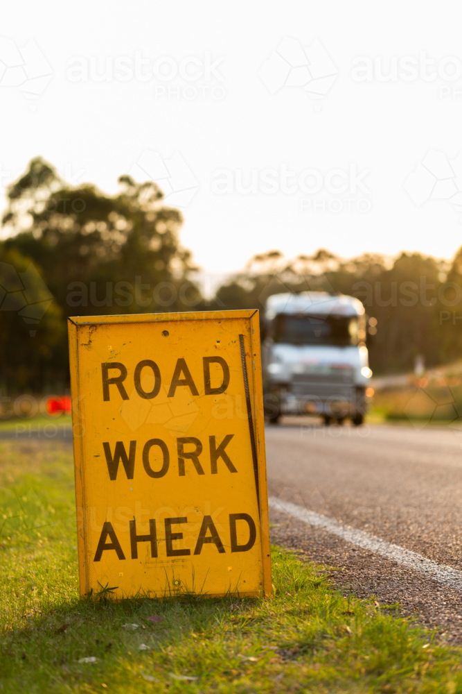 Image of Road work ahead sign beside road - Austockphoto