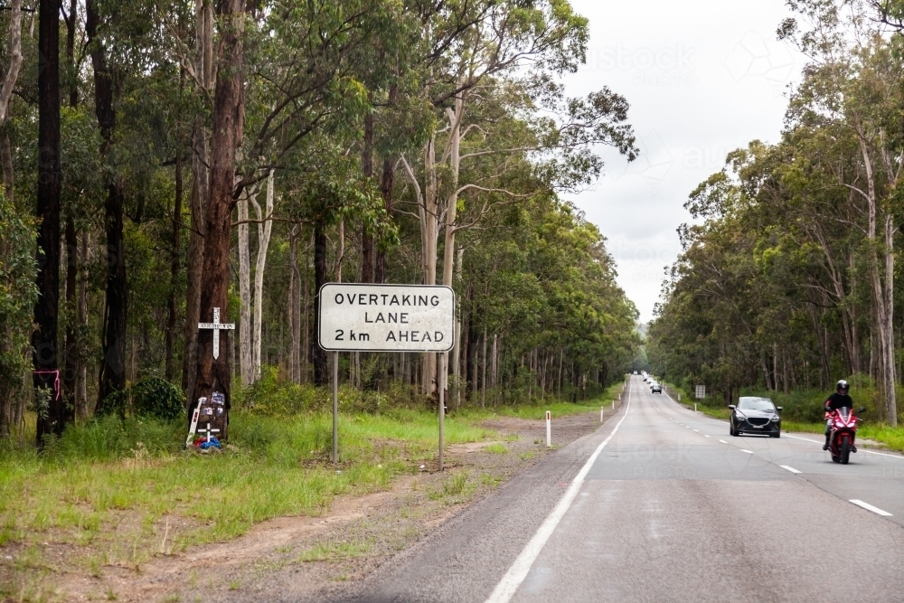 Image of Roadside memorial beside sign saying overtaking lane ahead ...