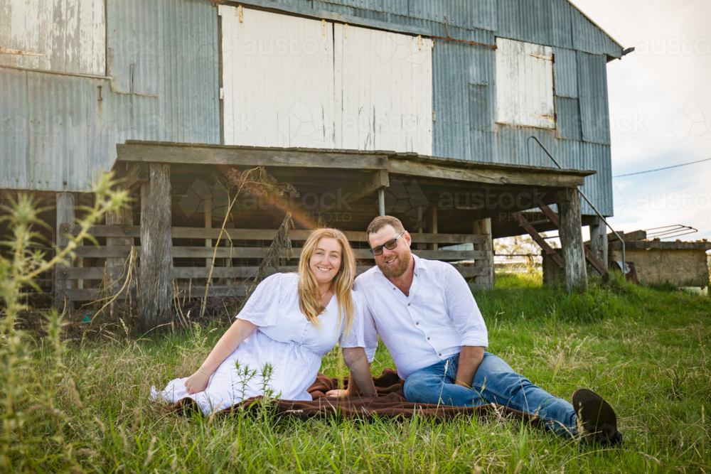 Image of Romantic portrait of man and woman sitting together on farm ...