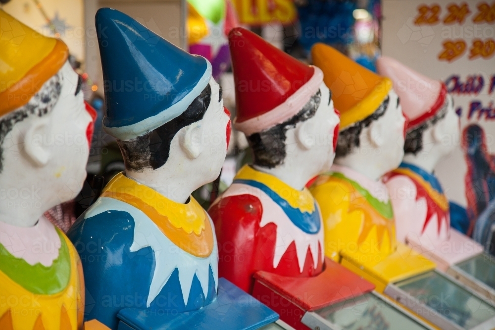 Image of Row of brightly coloured clown heads turning - Austockphoto