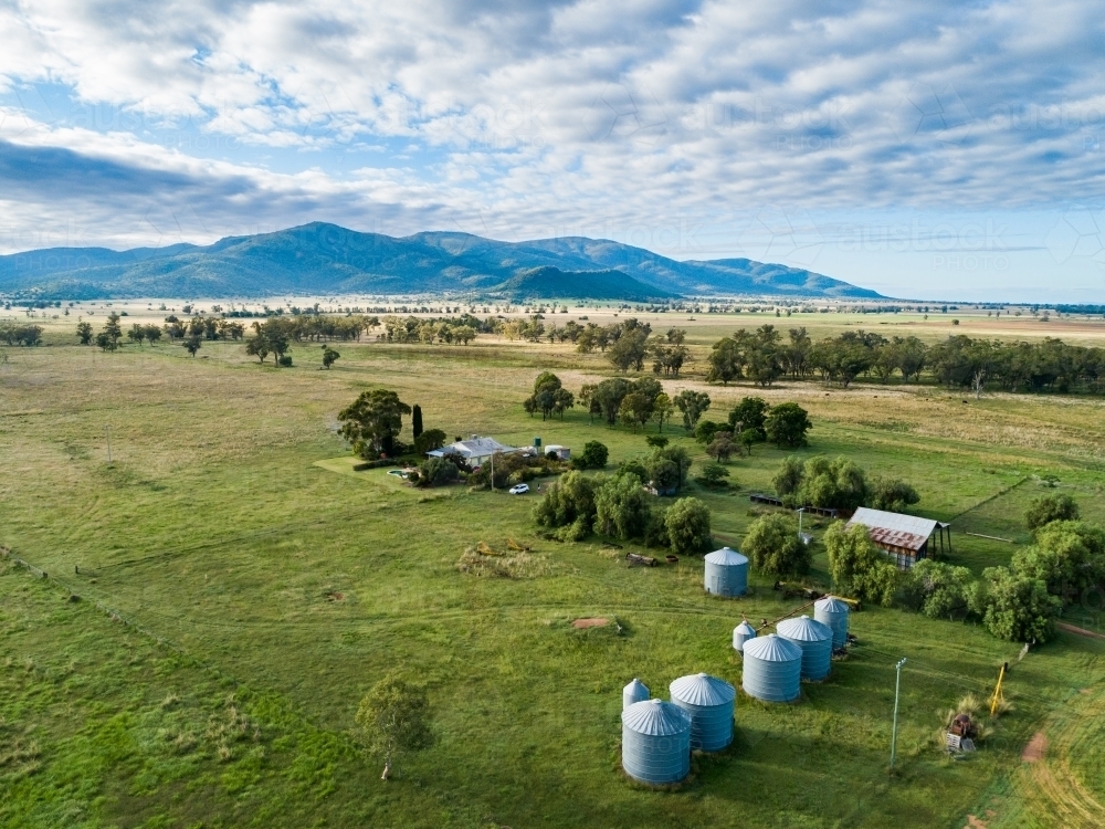 Image of Row of silos on country farm with homestead and hayshed behind ...