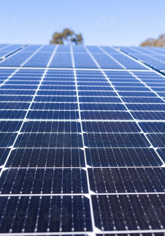 Image of Rows of blue solar panels up to sky on roof of home - Austockphoto