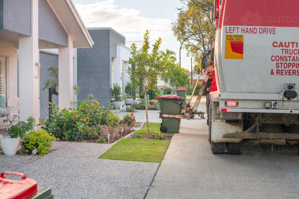 Image of rubbish truck arm picking up wheelie bin - Austockphoto