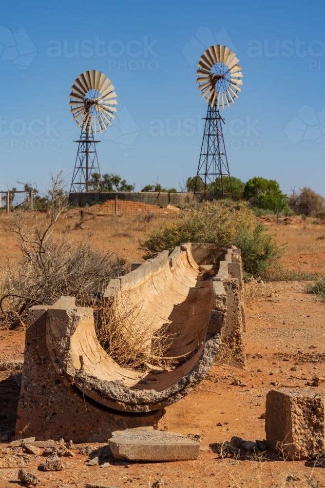 Image of Ruins of long water trough on an outback farm with two tall ...