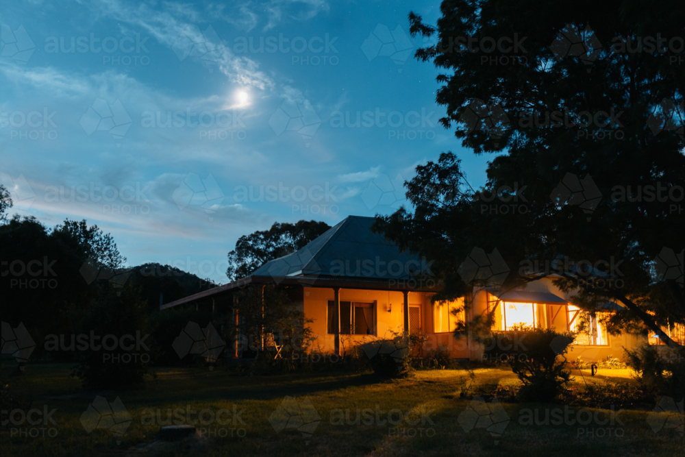 Image of Rural Australian homestead lit up at night under moonlit sky ...