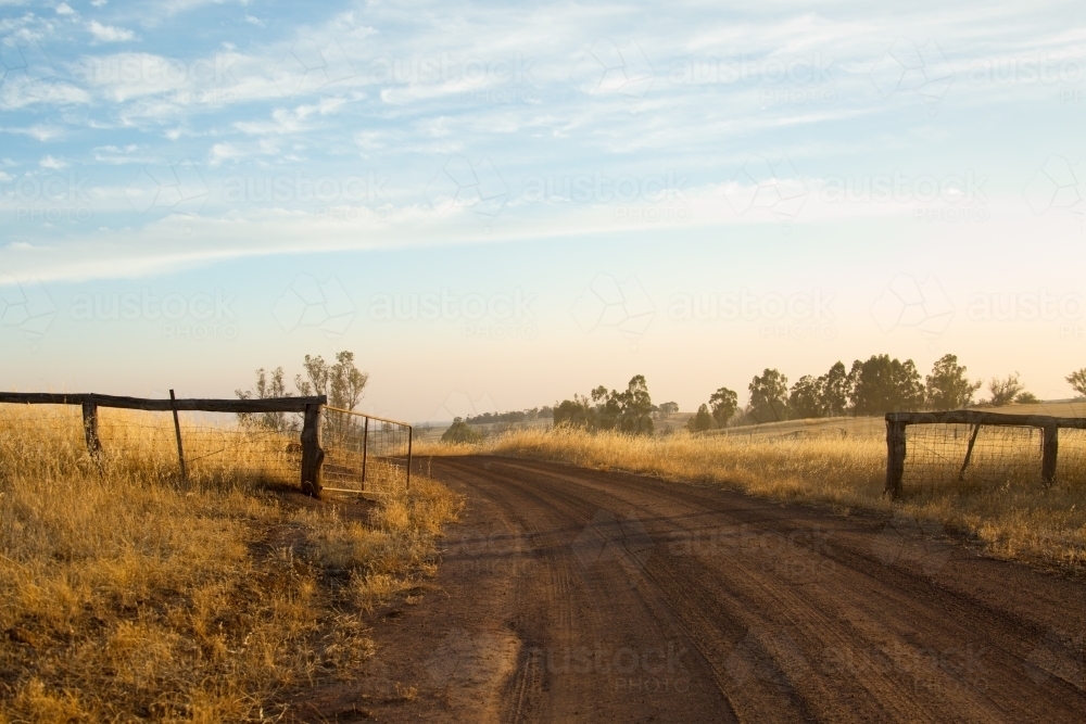 Image of Rural landscape with gravel road leading through gateway ...