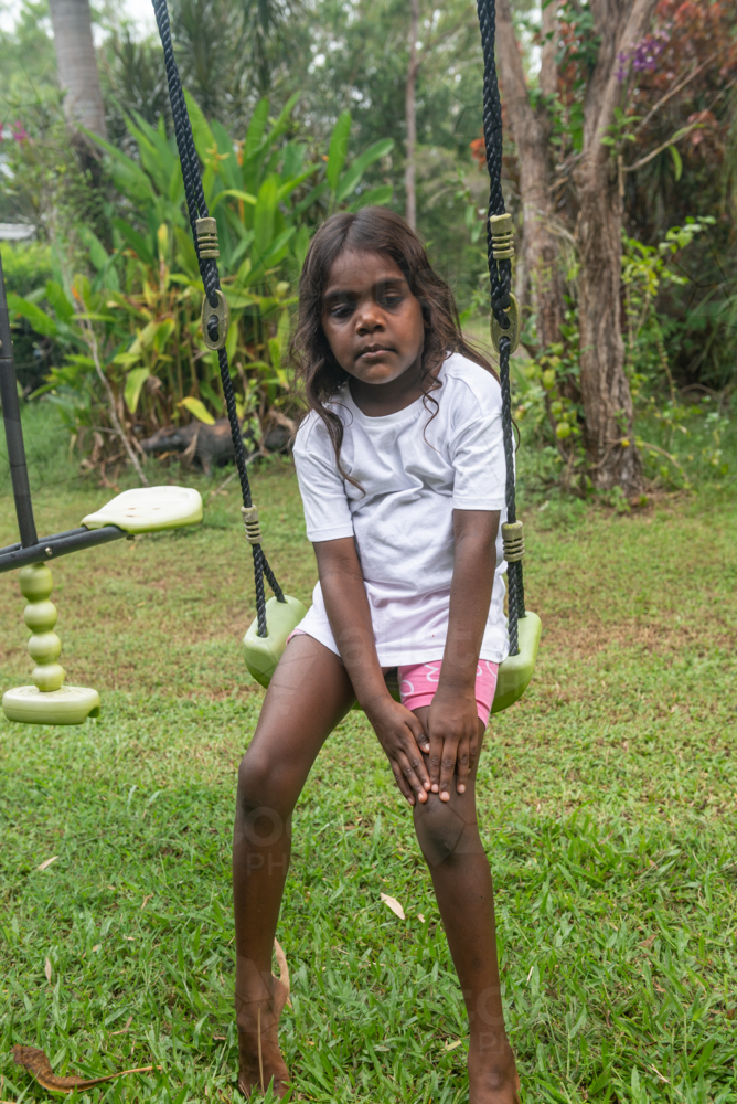 Image of Sad 4 yo aboriginal child holding sore knee in hand - Austockphoto