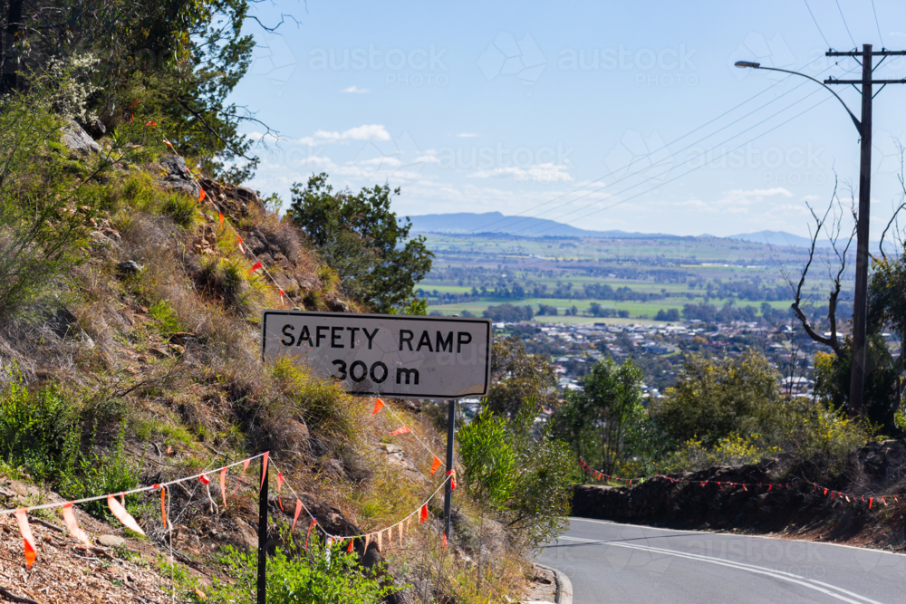 Image of safety ramp 300m sign beside road on steep descent - Austockphoto