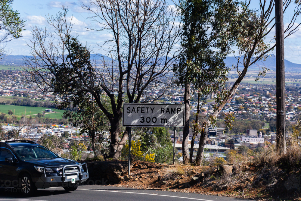 Image of safety ramp 300m sign beside road on steep descent - Austockphoto