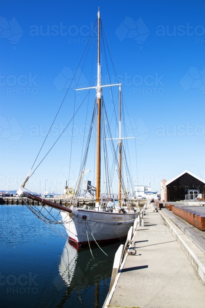Image of Sailboat docked at wharf - Austockphoto